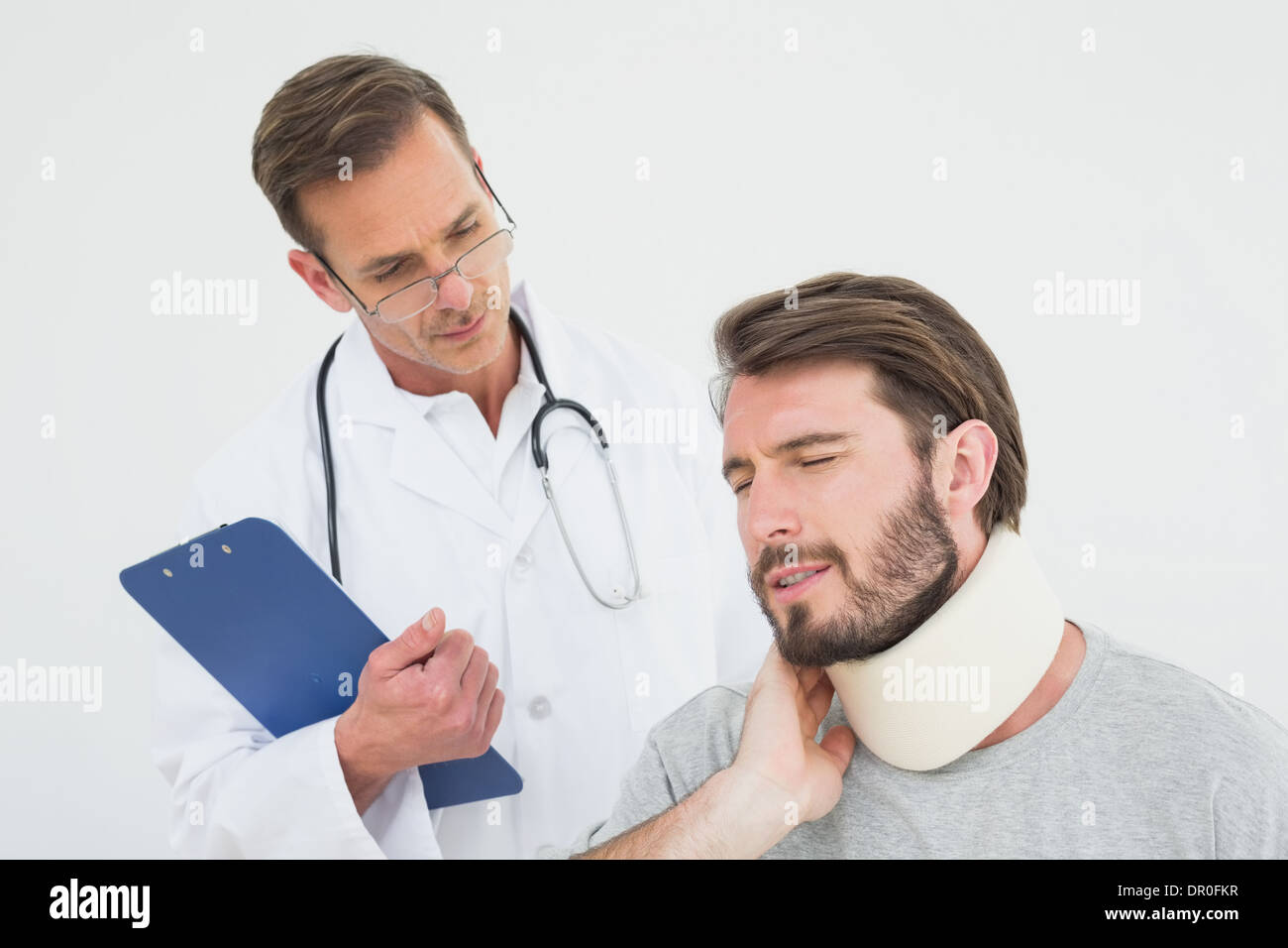 Male doctor examining a patient's sprained neck Stock Photo - Alamy