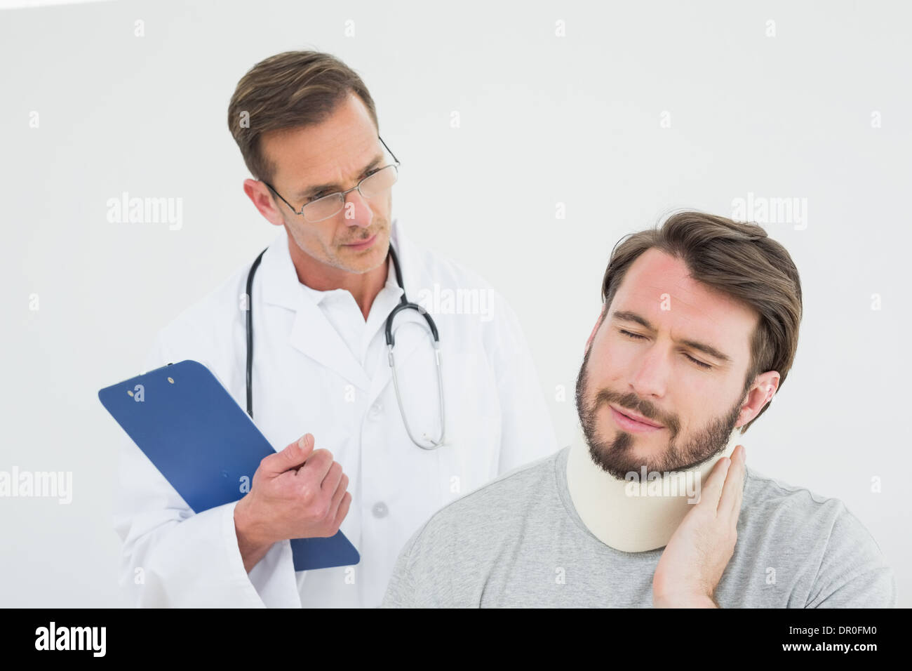 Male doctor examining a patient's sprained neck Stock Photo - Alamy