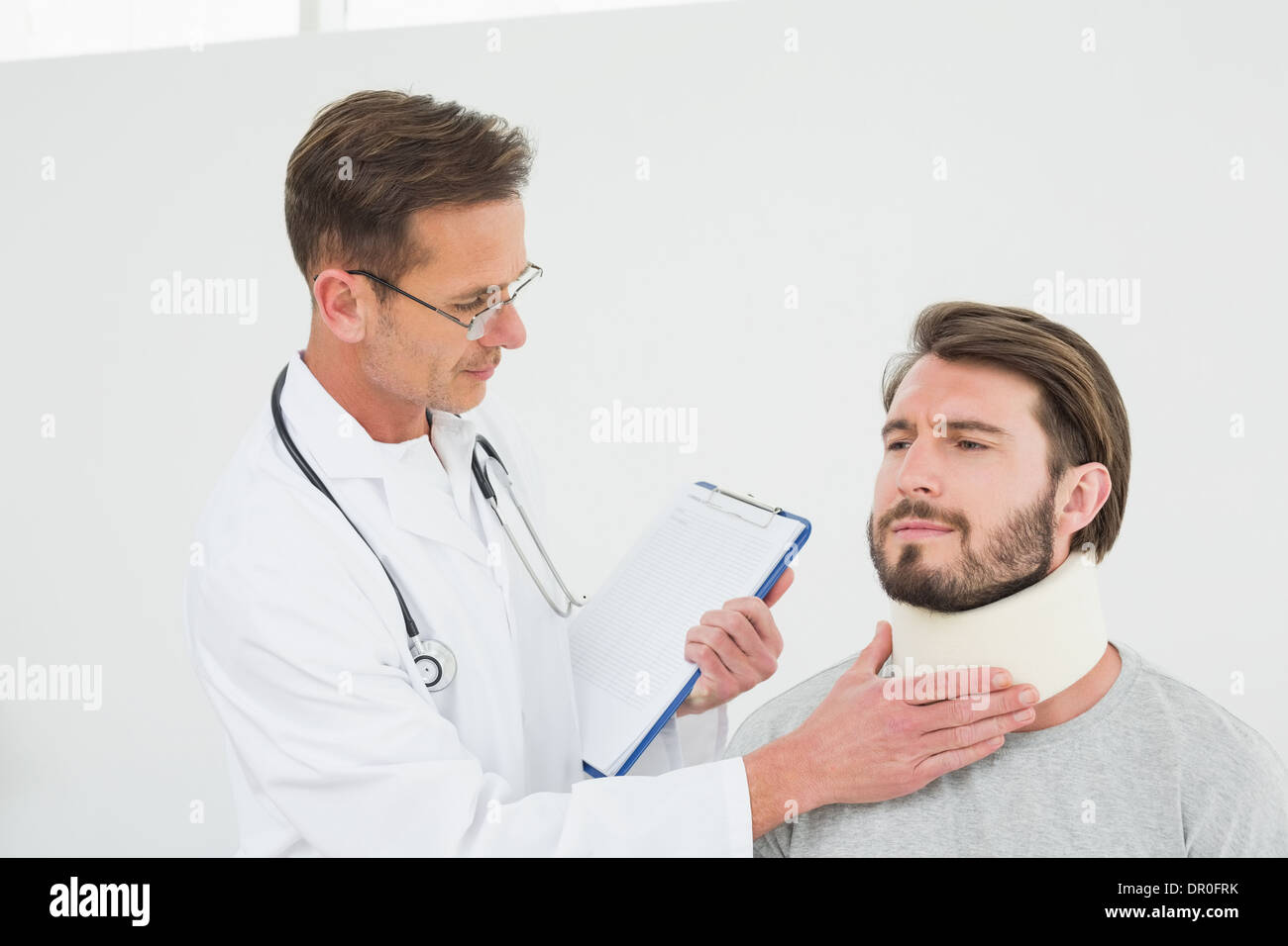 Male doctor examining a patient's sprained neck Stock Photo - Alamy