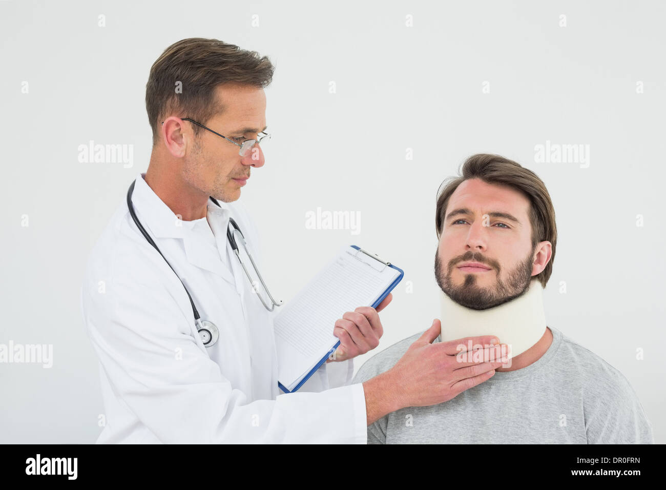 Male doctor examining a patient's sprained neck Stock Photo - Alamy