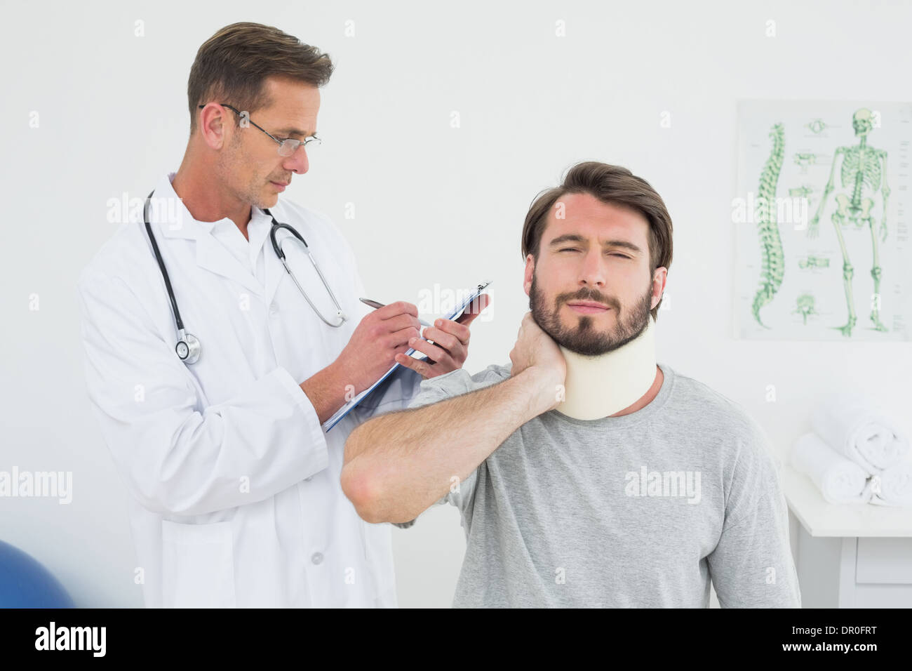 Male doctor examining a patient's sprained neck Stock Photo - Alamy