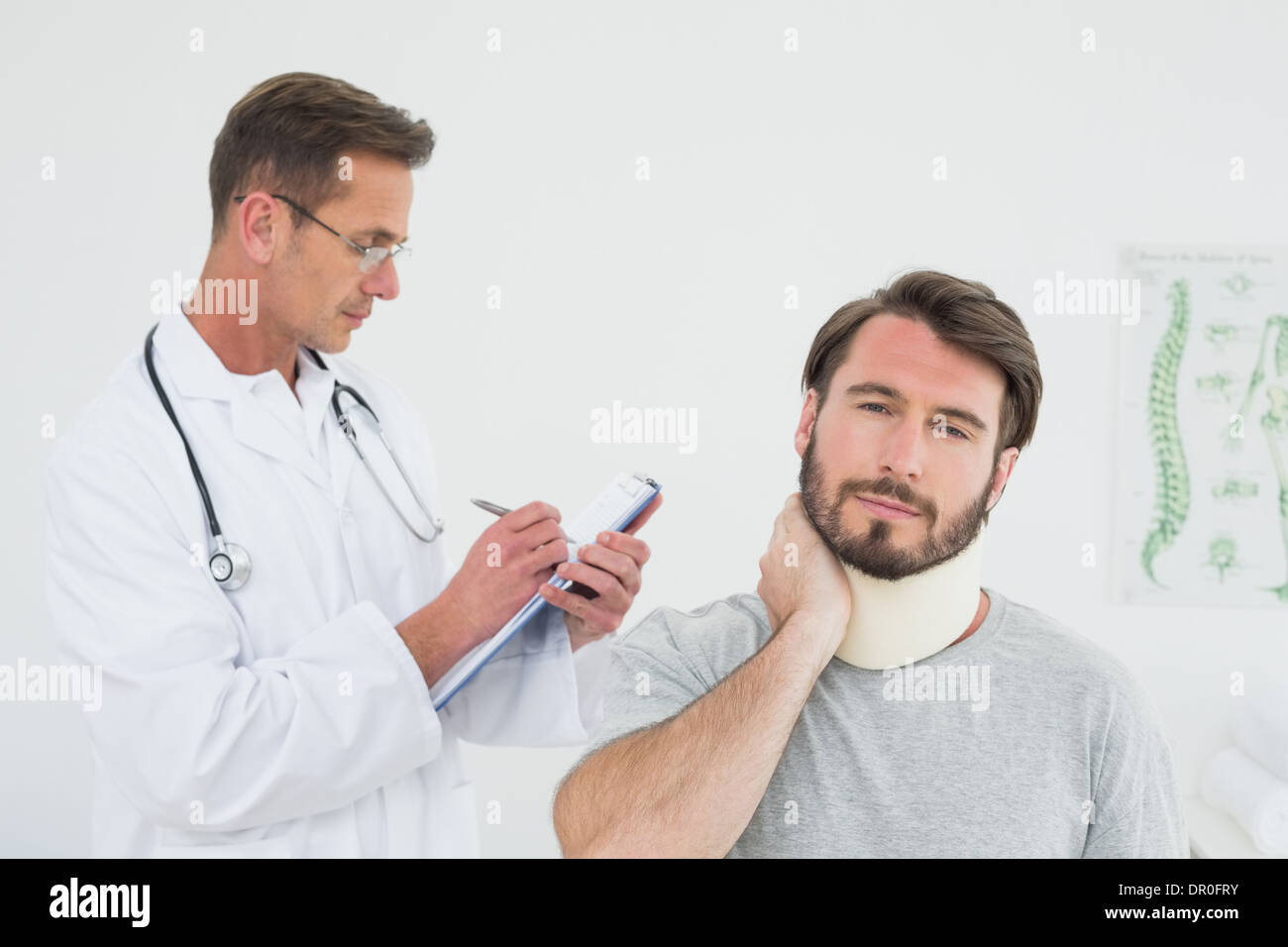 Male doctor examining a patient's sprained neck Stock Photo - Alamy