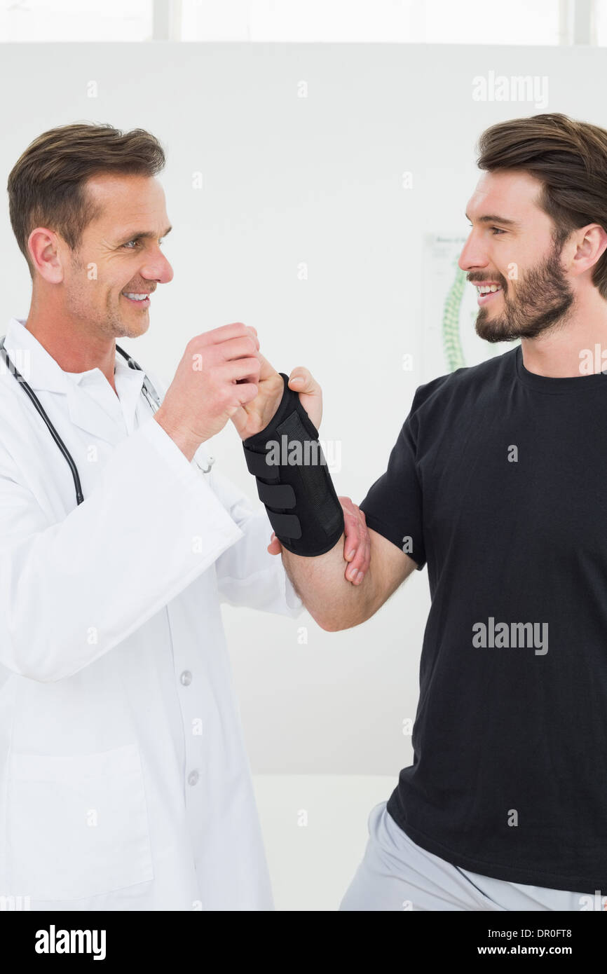 Male physiotherapist examining a young man's wrist Stock Photo - Alamy