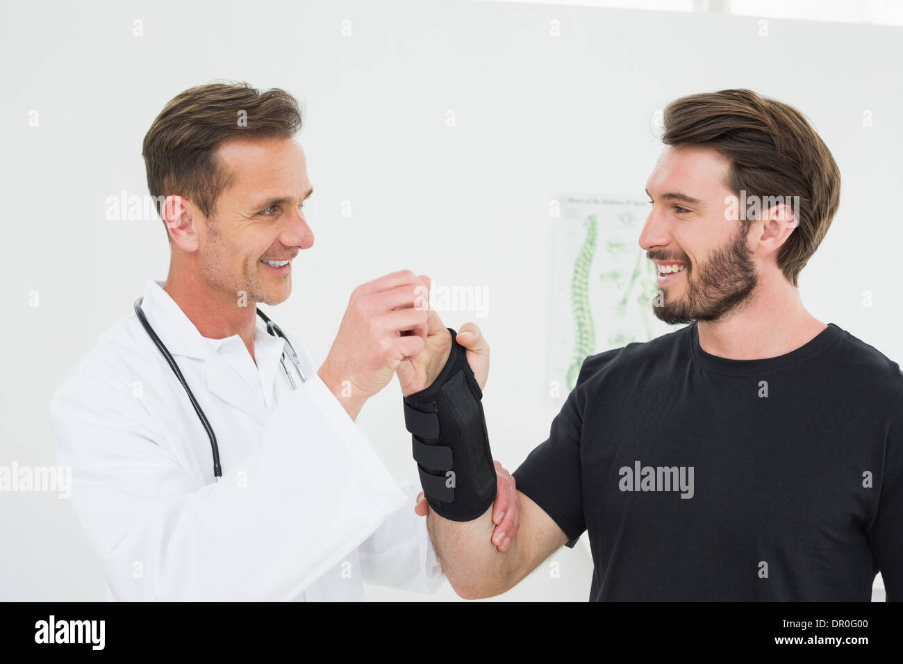 Male physiotherapist examining a young man's wrist Stock Photo - Alamy