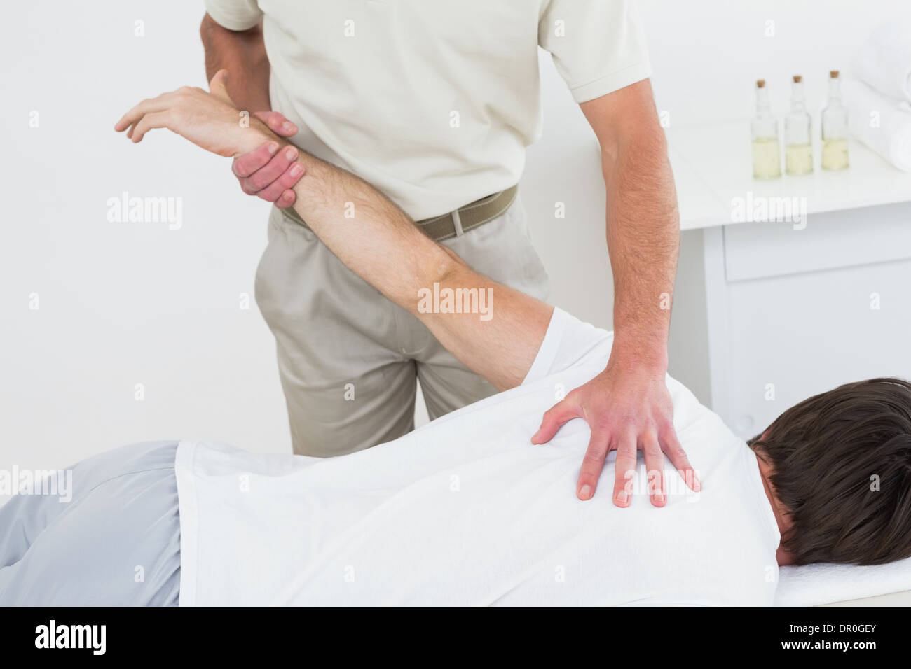 Male physiotherapist stretching a man's hand Stock Photo - Alamy