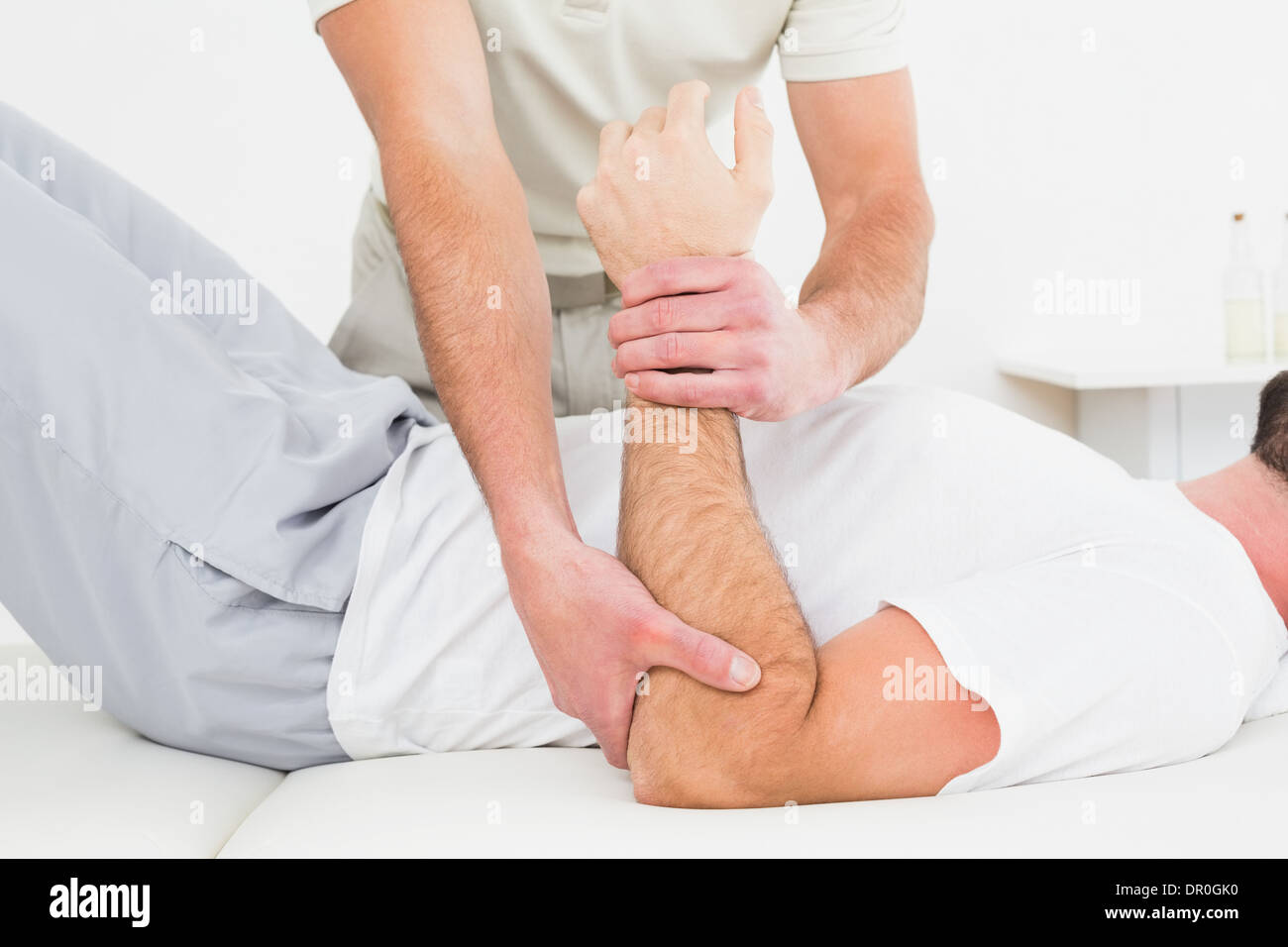 Mid section of physiotherapist examining a man's hand Stock Photo - Alamy