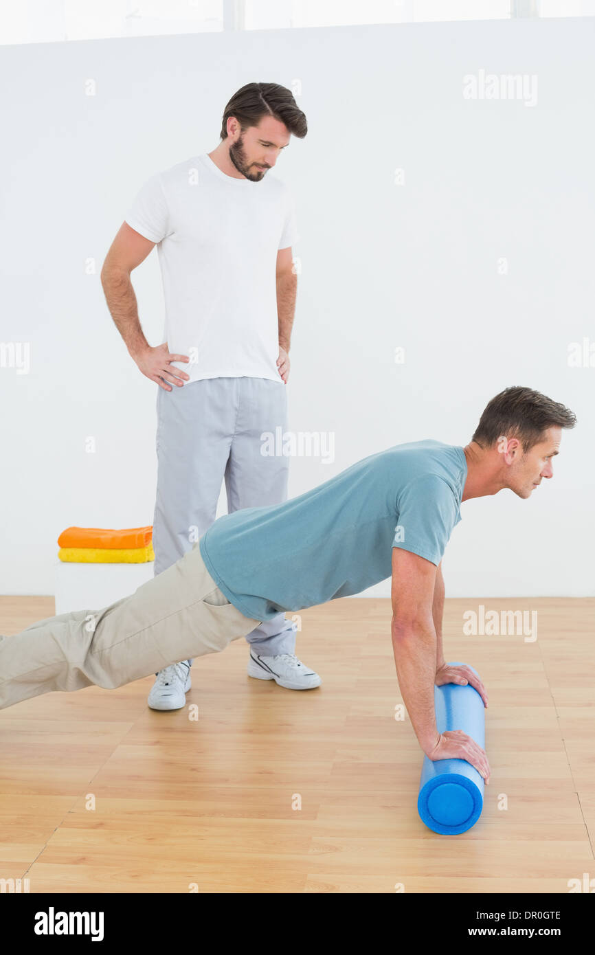 Physical therapist watching young man do push ups Stock Photo - Alamy