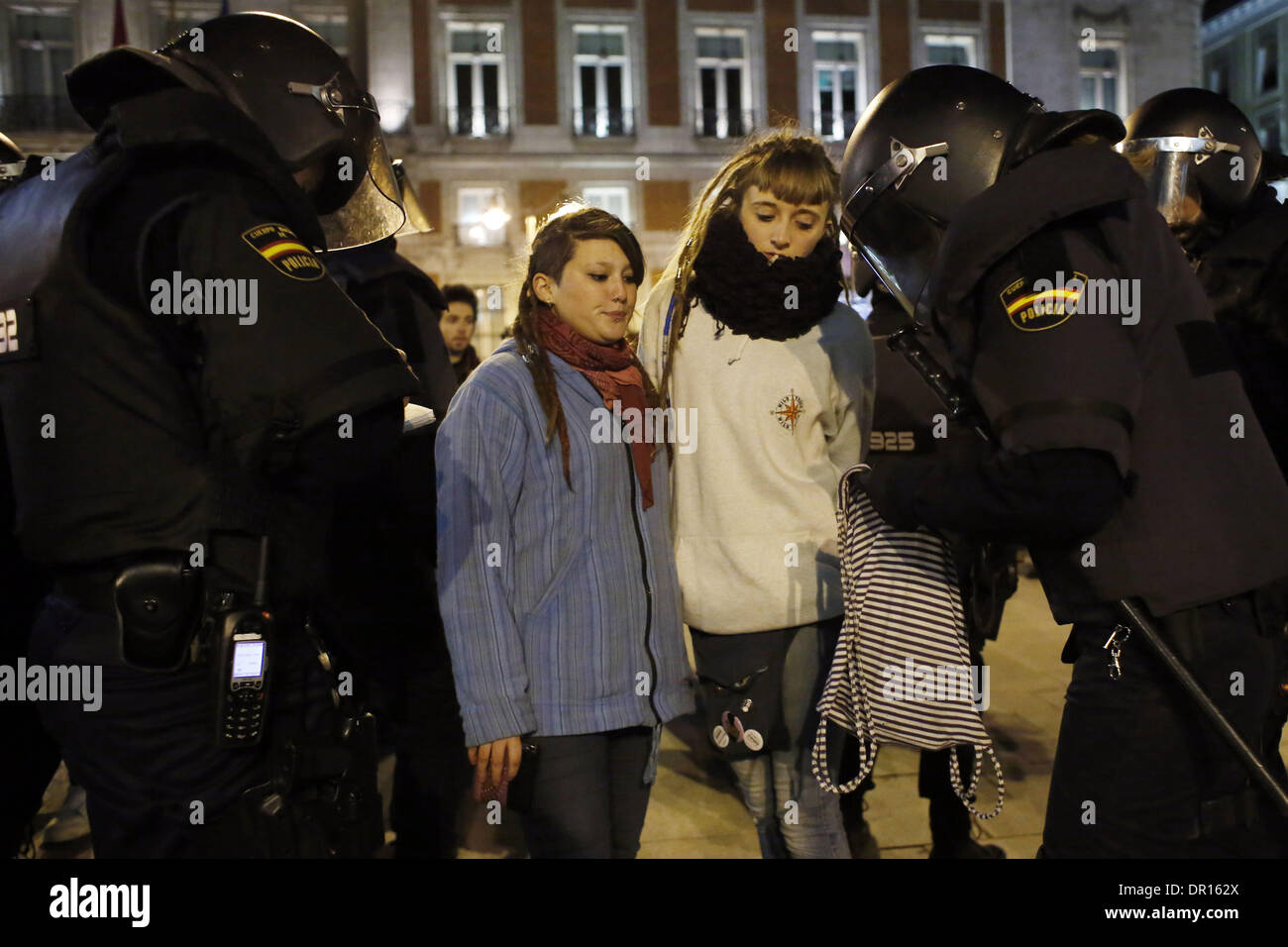 Madrid, Spain. 16th Jan, 2014. Two protestors look at a riot police ...
