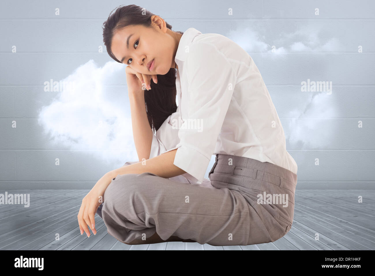 Composite image of businesswoman sitting cross legged leaning on hand ...