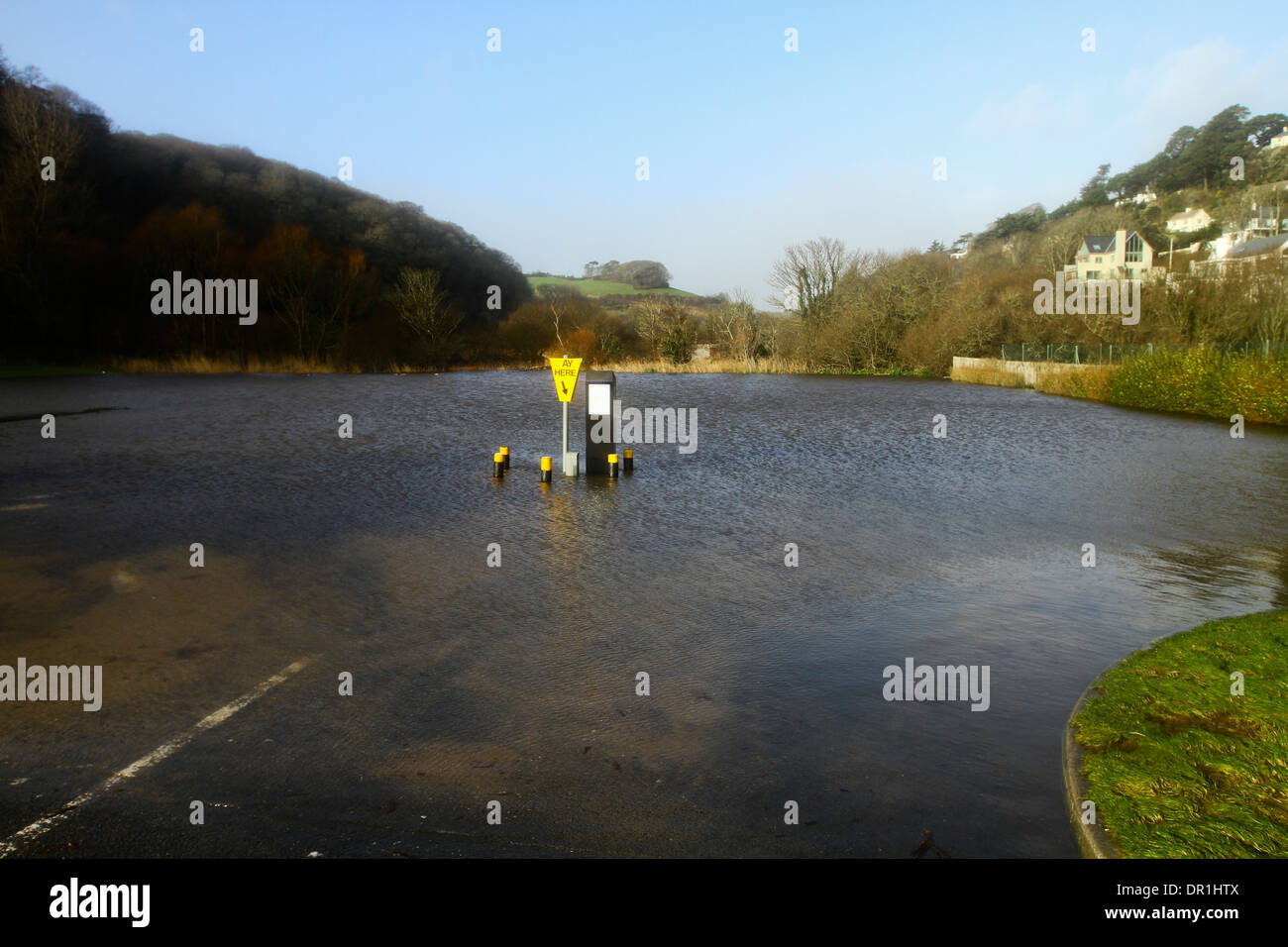 Flooded Car park ticket machine as island Devon Floods Workman Stock ...