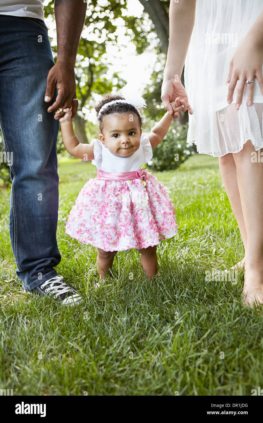 Parents helping daughter walk hi-res stock photography and images - Alamy
