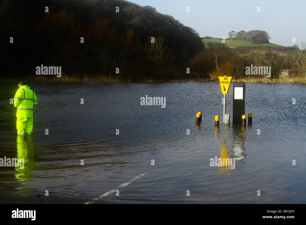 Flooded Car park ticket machine as island Devon Floods Workman Stock ...