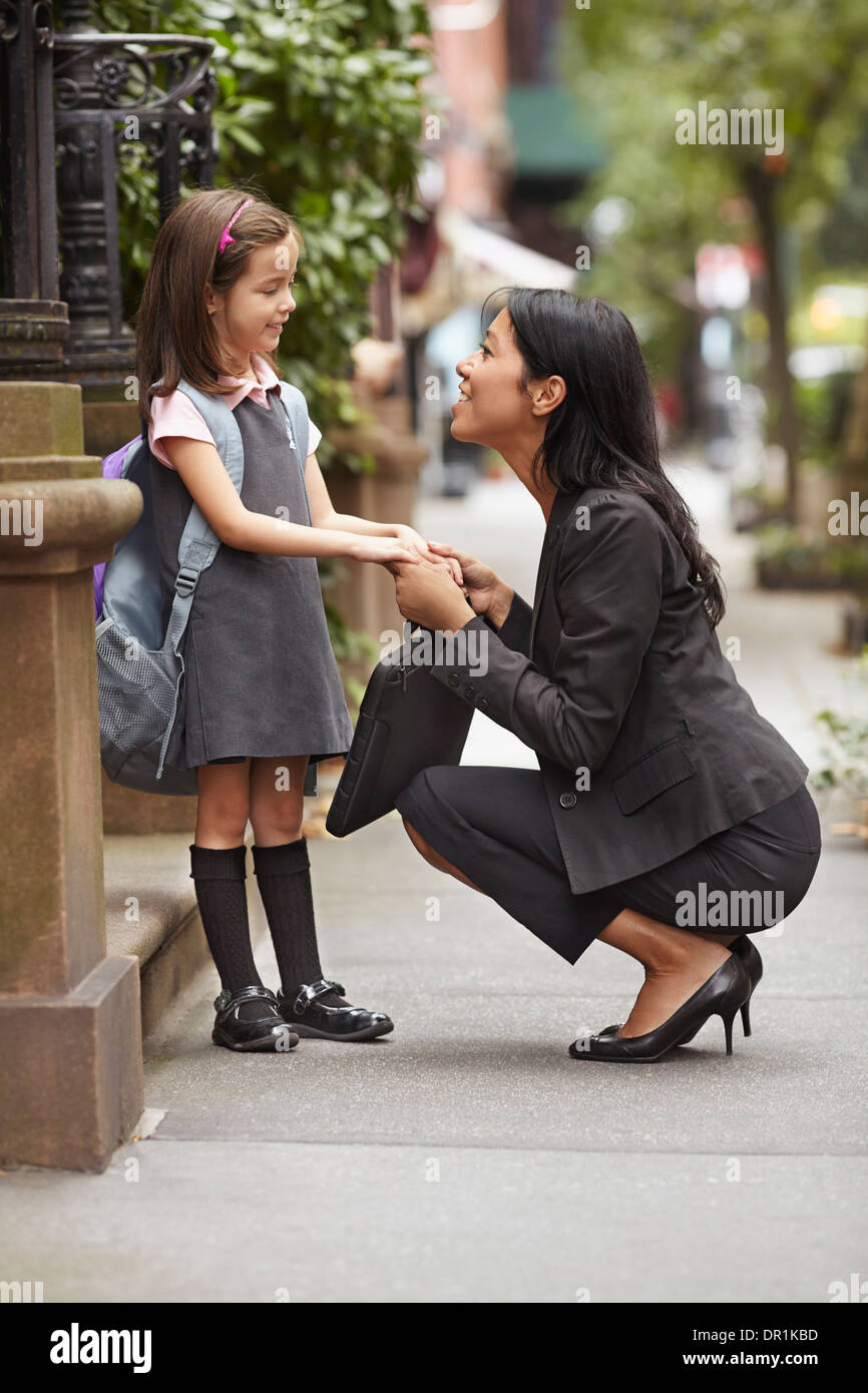 Mother greeting daughter on city street Stock Photo - Alamy