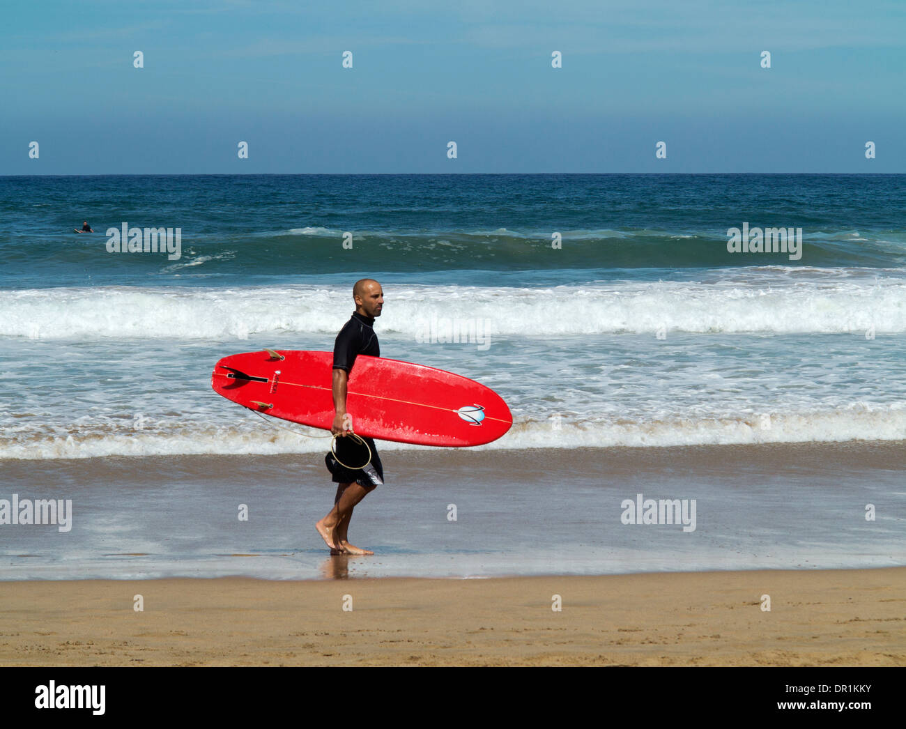 surfer with board standing on edge of surf at Zurriola beach in Gros ...