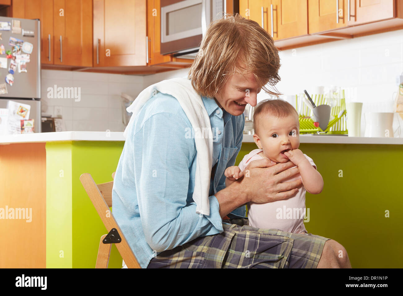 Father holding baby in kitchen Stock Photo - Alamy