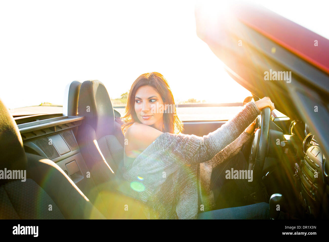 Woman driving convertible at sunset Stock Photo - Alamy