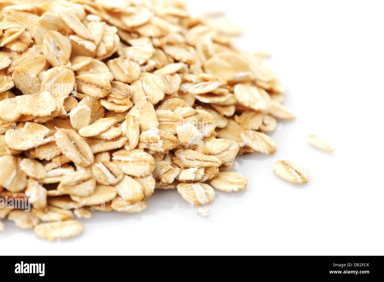 Oat flakes heap isolated on white background Stock Photo - Alamy