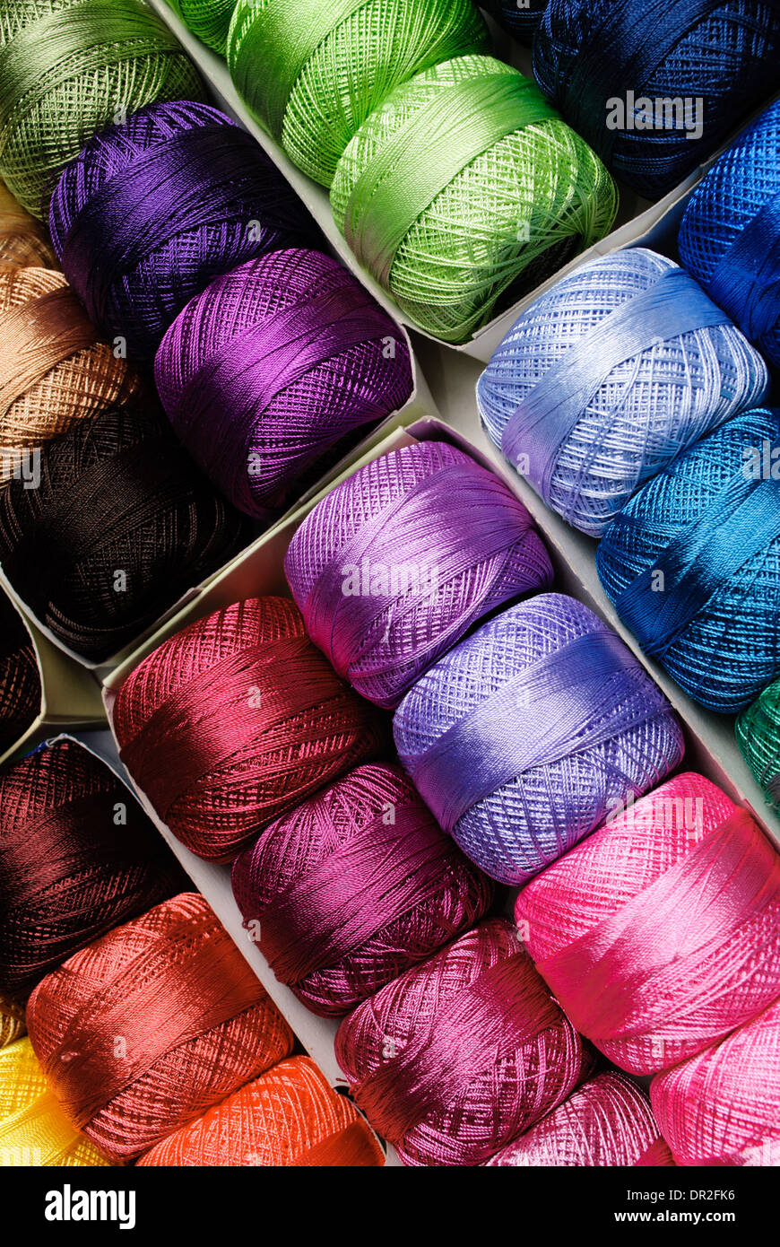 Different color threads on rows in the store Stock Photo - Alamy
