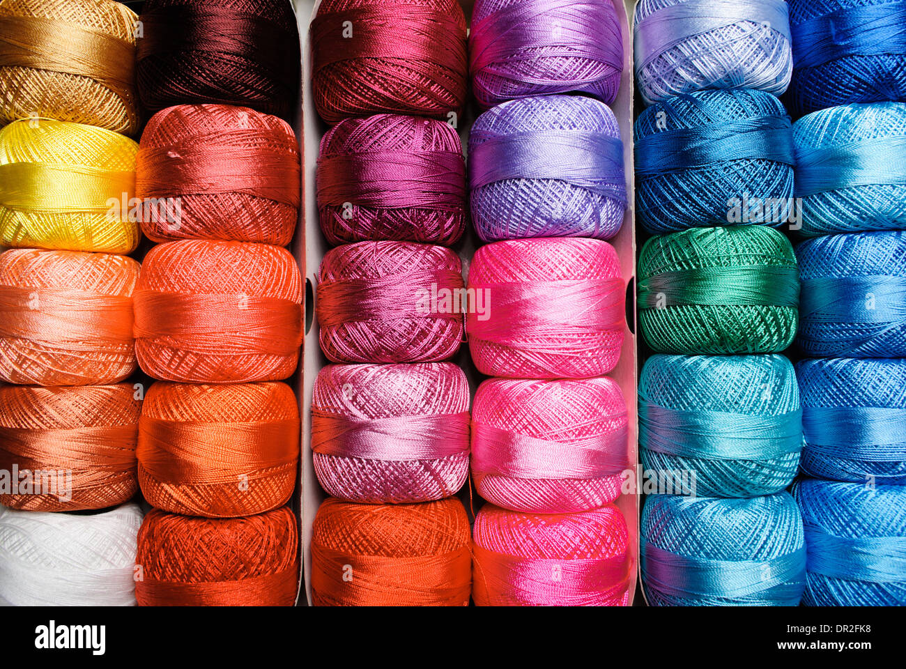 Different color threads on rows in the store Stock Photo - Alamy
