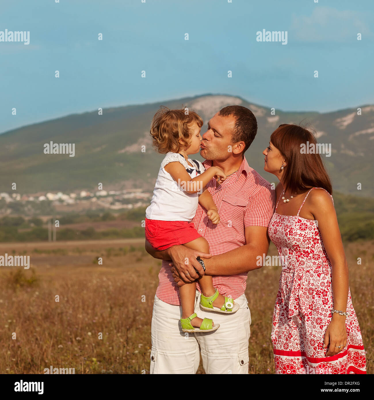 Happy mother, father and daughter in sunset Stock Photo - Alamy