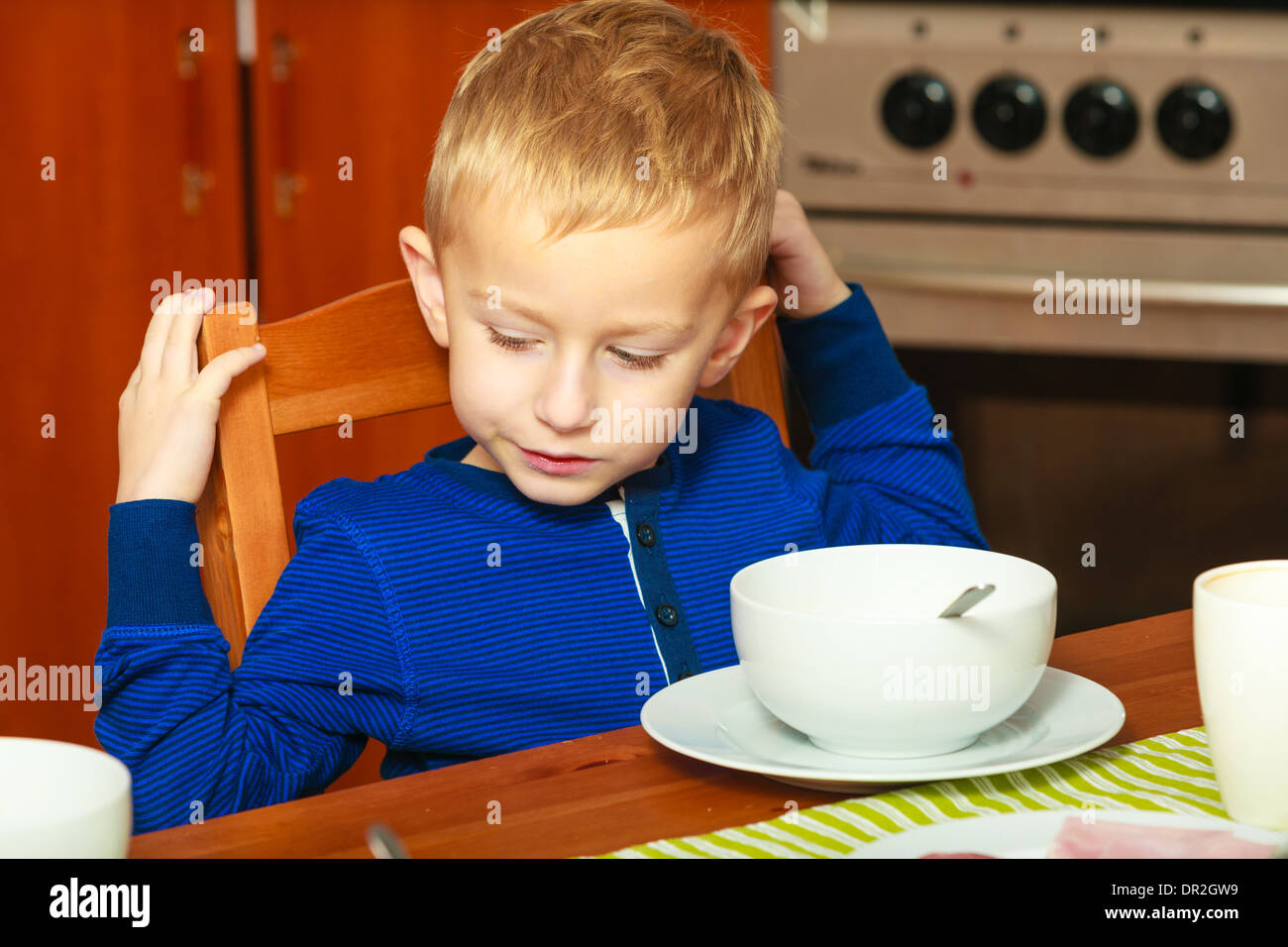 Happy childhood. Blond boy kid child eating corn flakes cereal with ...