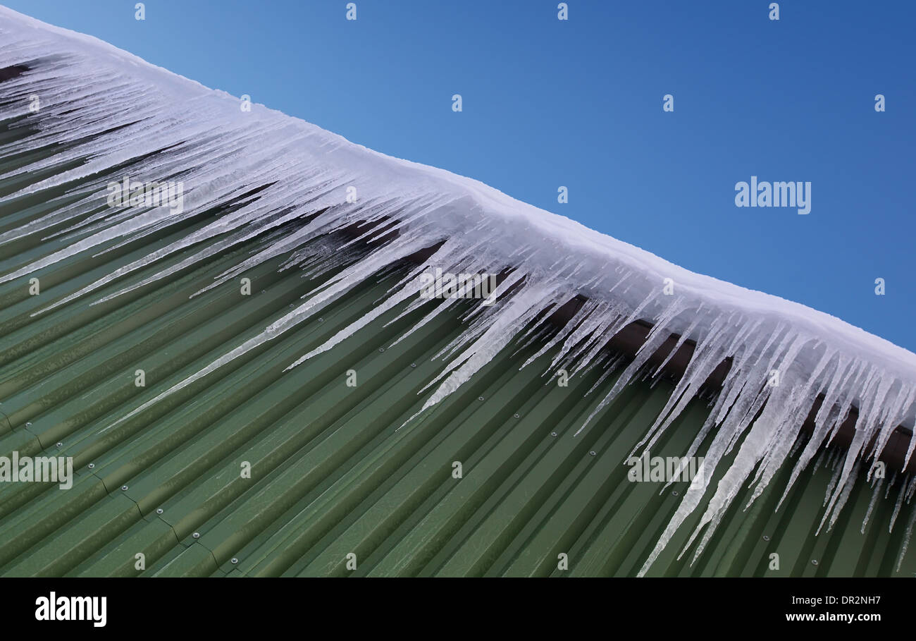 Huge icicles hang down from roof Stock Photo - Alamy