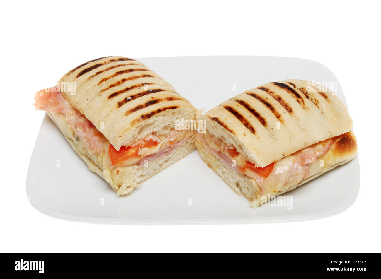 Ham, tomato and melted cheese panini on a plate isolated against white ...