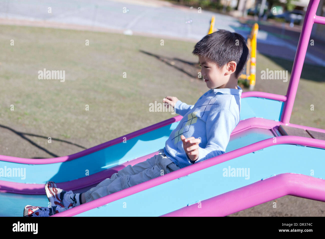 Boy sliding down slide Stock Photo - Alamy