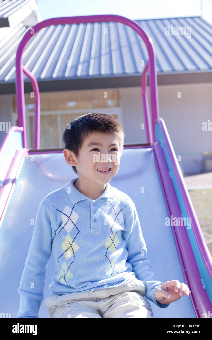Boy sliding down slide Stock Photo - Alamy