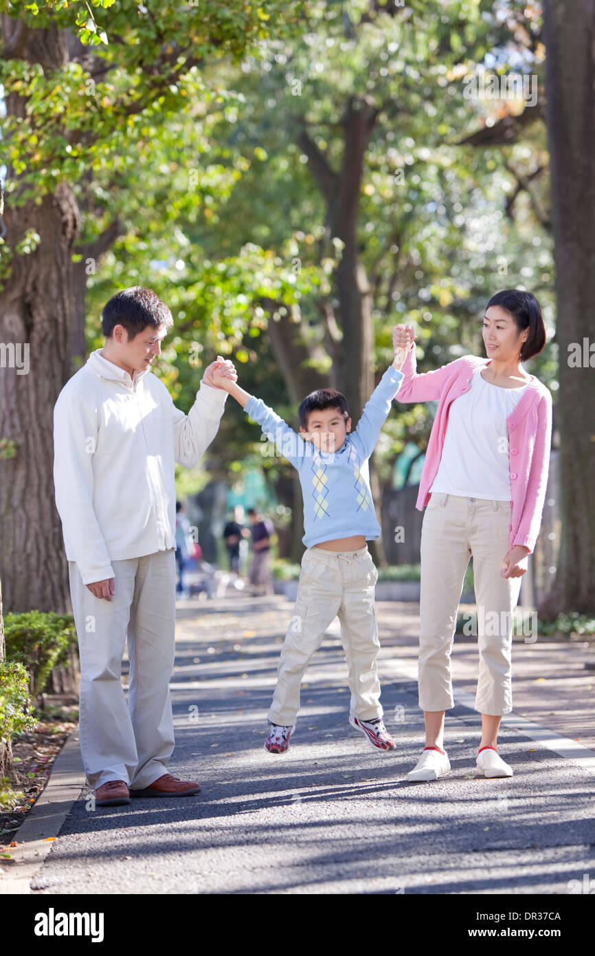 Parents lifting son by hands Stock Photo - Alamy