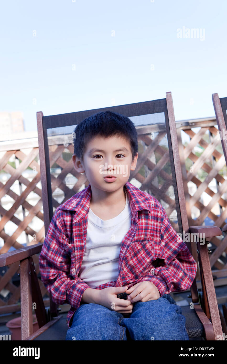 Boy sitting on chair Stock Photo - Alamy