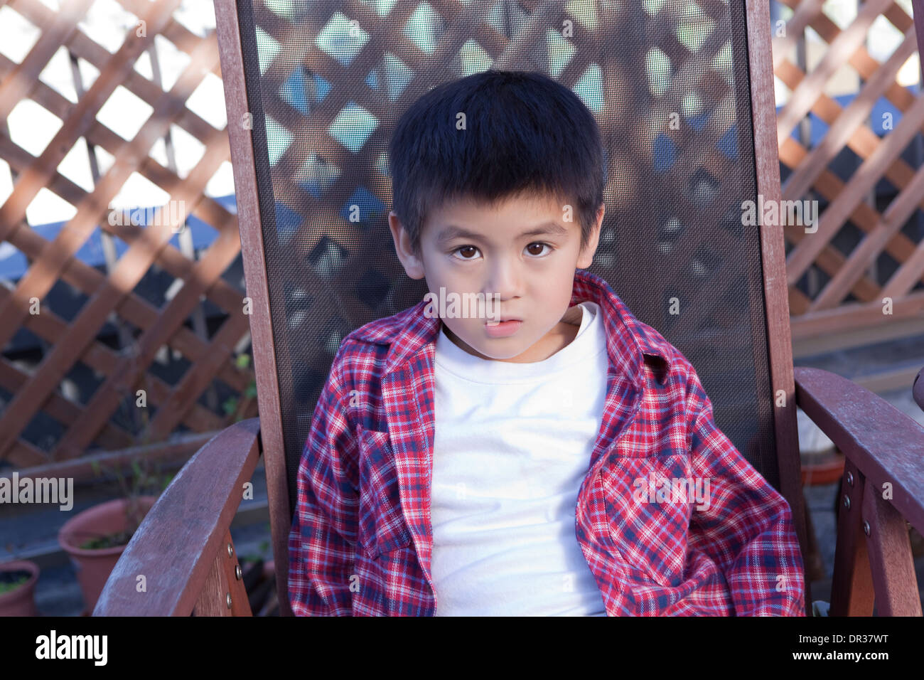 Boy sitting on chair Stock Photo - Alamy