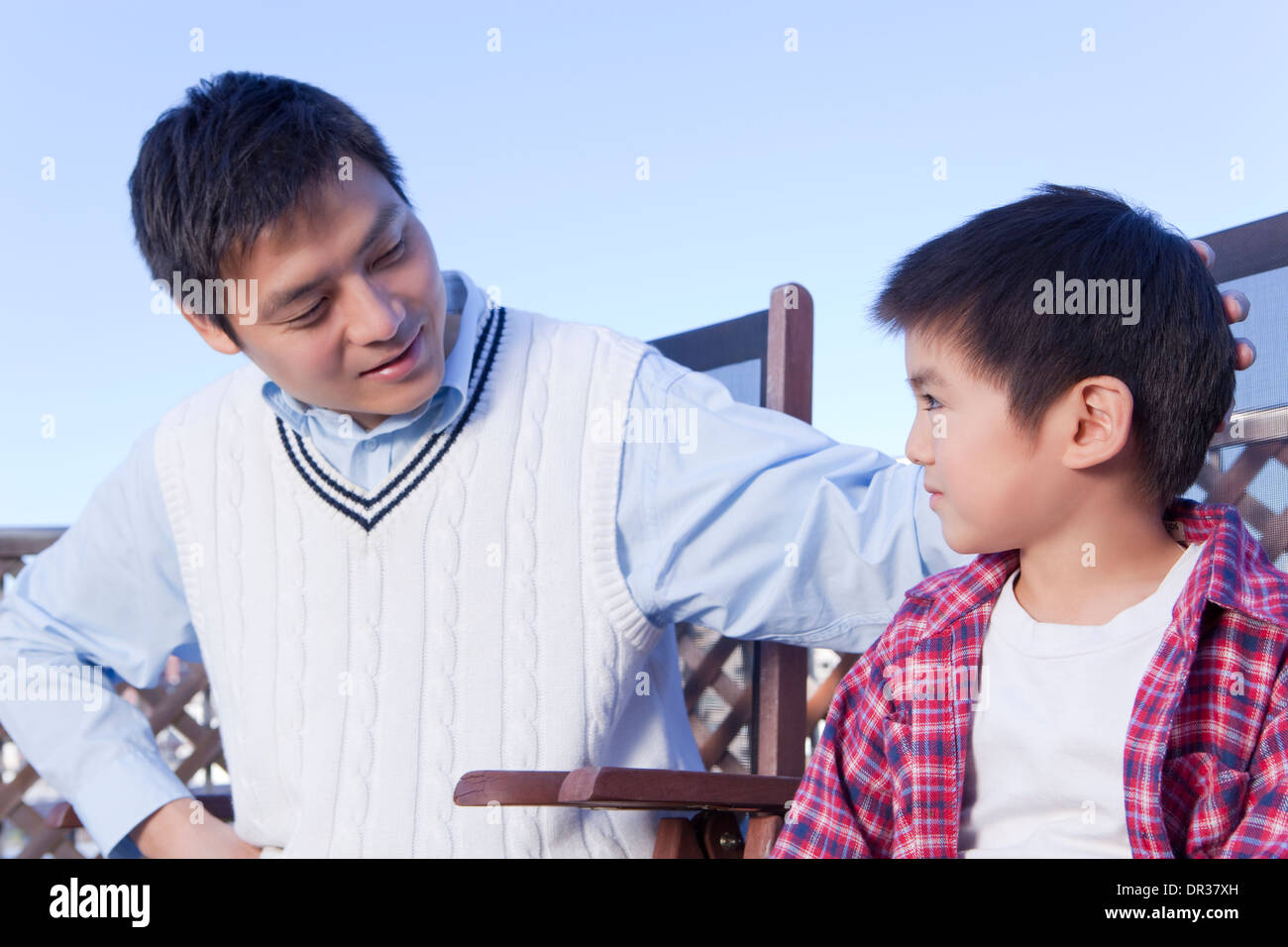 Father patting son on head Stock Photo - Alamy
