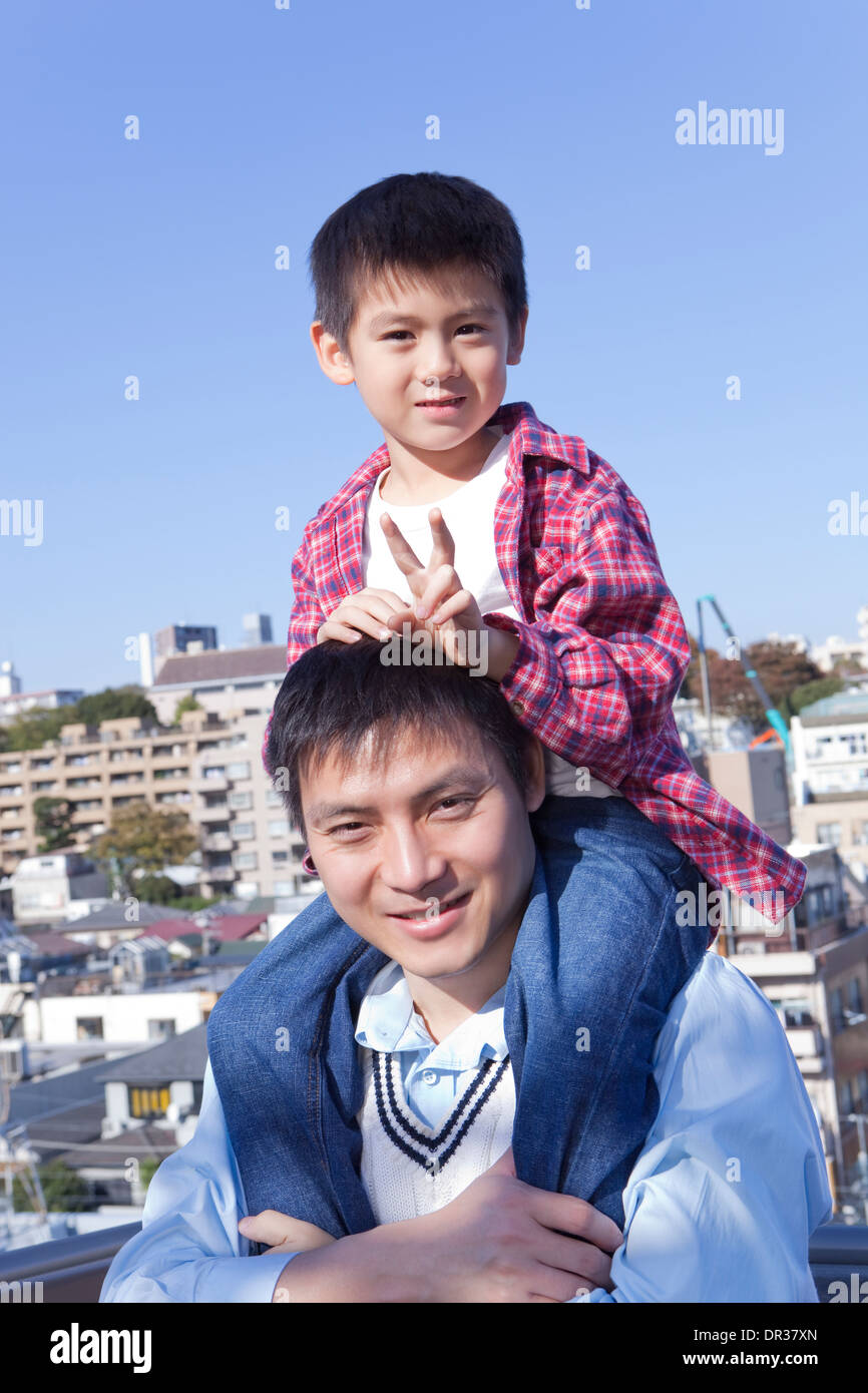 Son sitting on father's shoulders Stock Photo - Alamy