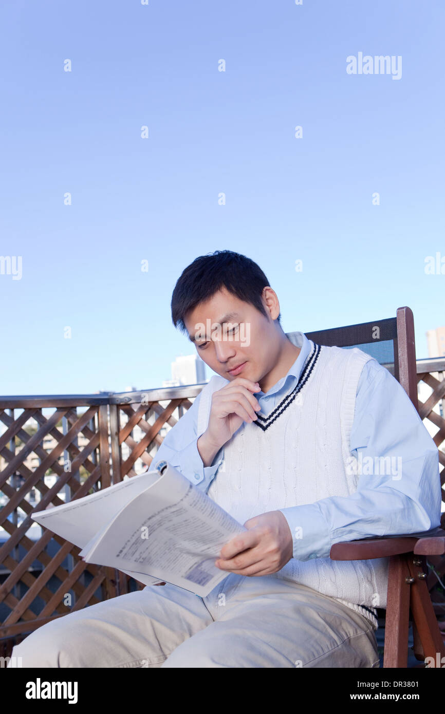 Mid adult man reading magazine Stock Photo - Alamy