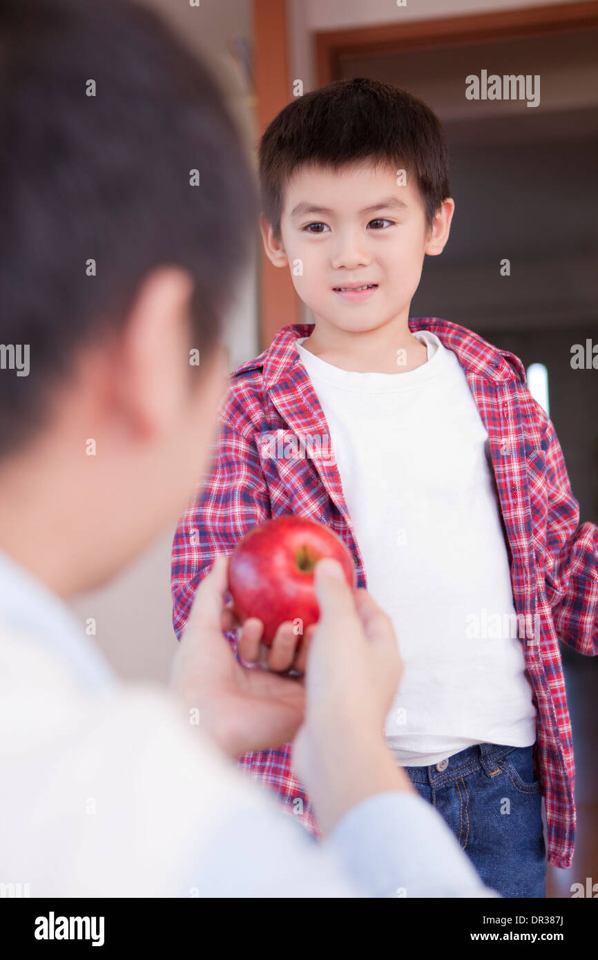 Son giving apple to father Stock Photo - Alamy