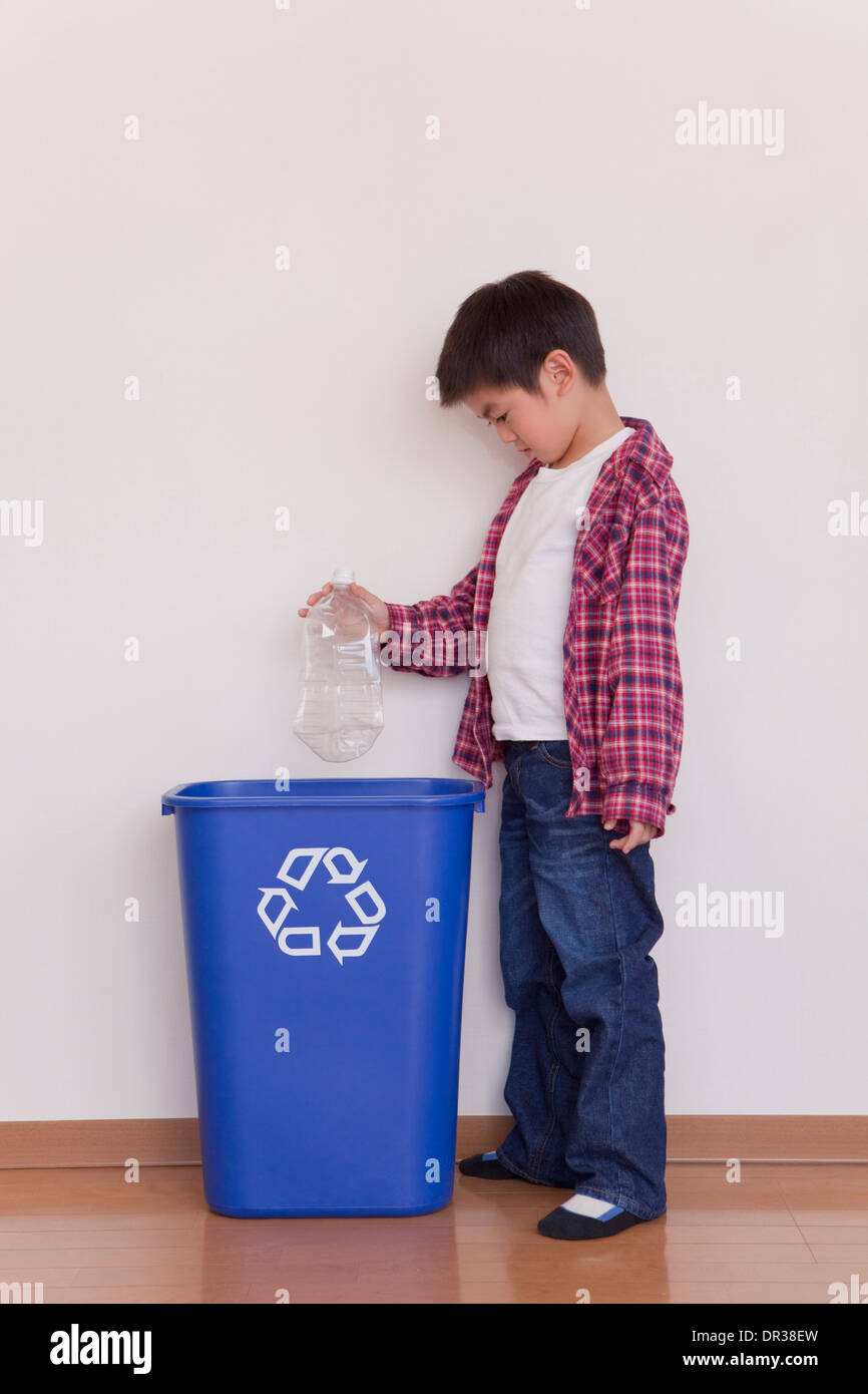 Boy putting plastic bottle in recycling bin Stock Photo - Alamy