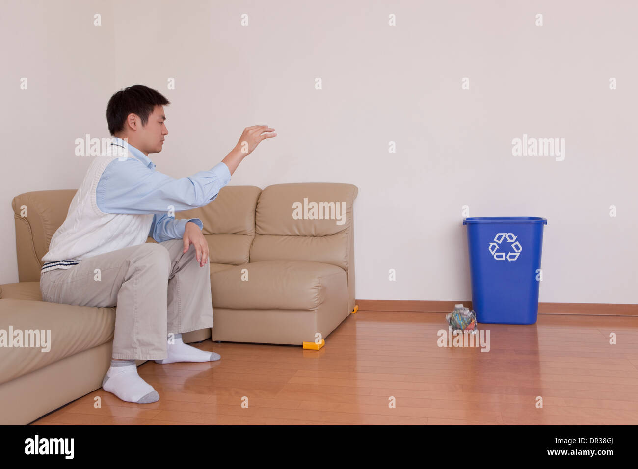 Mid adult man throwing garbage into recycling bin Stock Photo - Alamy