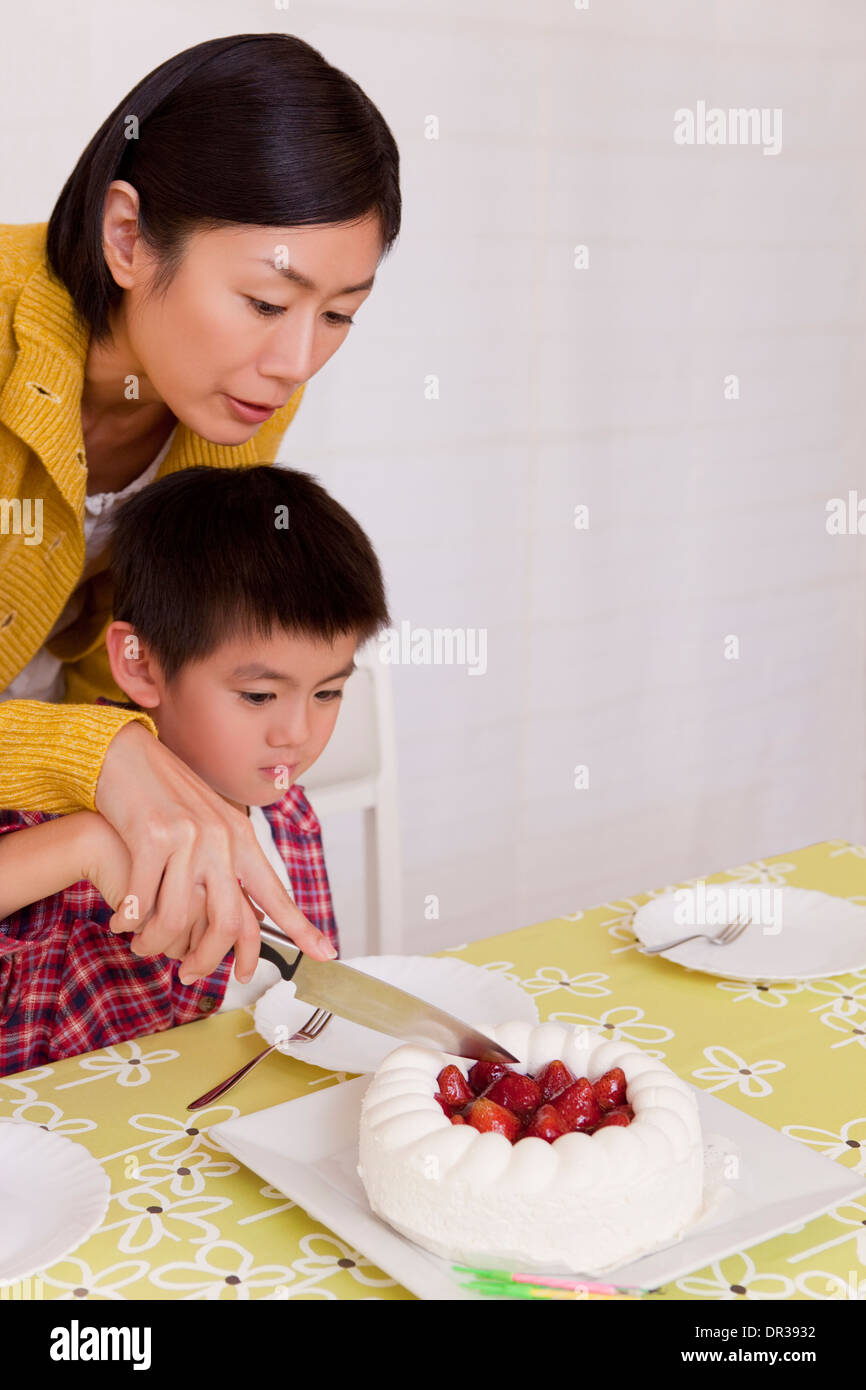 Mother and son cutting birthday cake Stock Photo - Alamy
