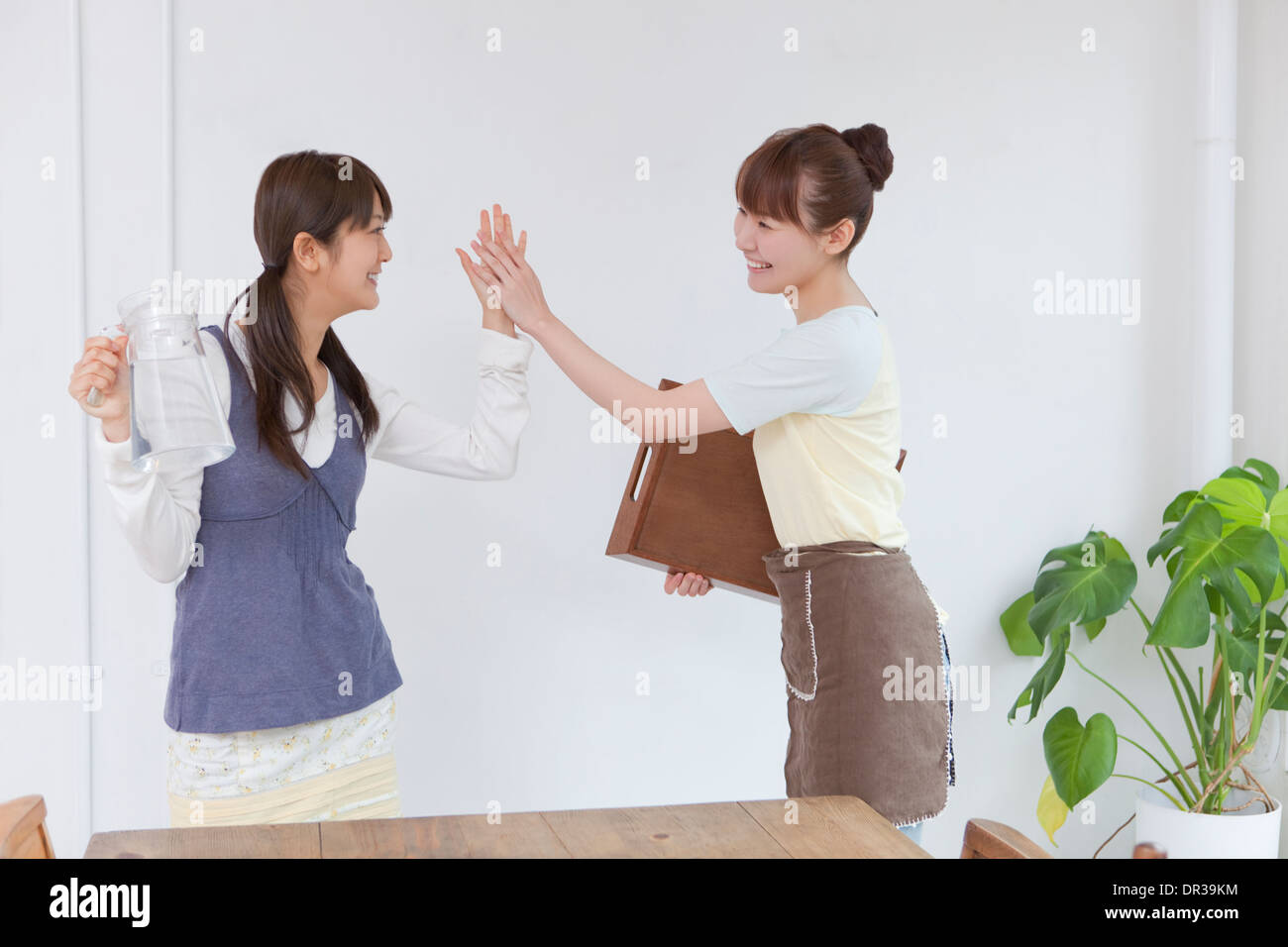 Two young women giving each other high five Stock Photo - Alamy