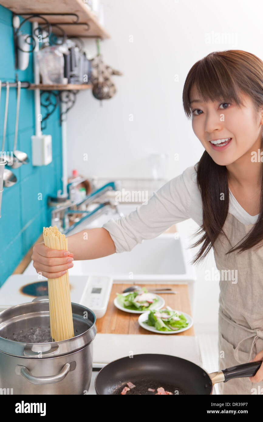 Young woman cooking pasta Stock Photo - Alamy