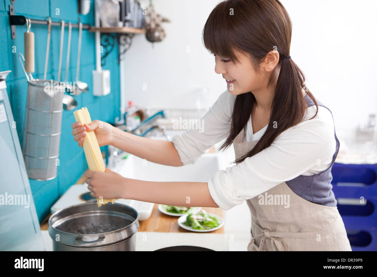 Young woman cooking pasta Stock Photo - Alamy