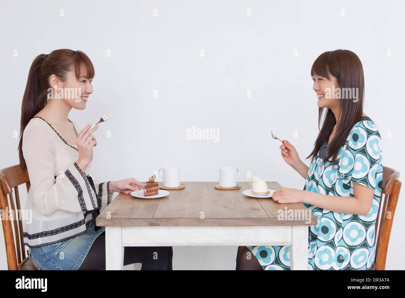 Two young women eating cake Stock Photo - Alamy
