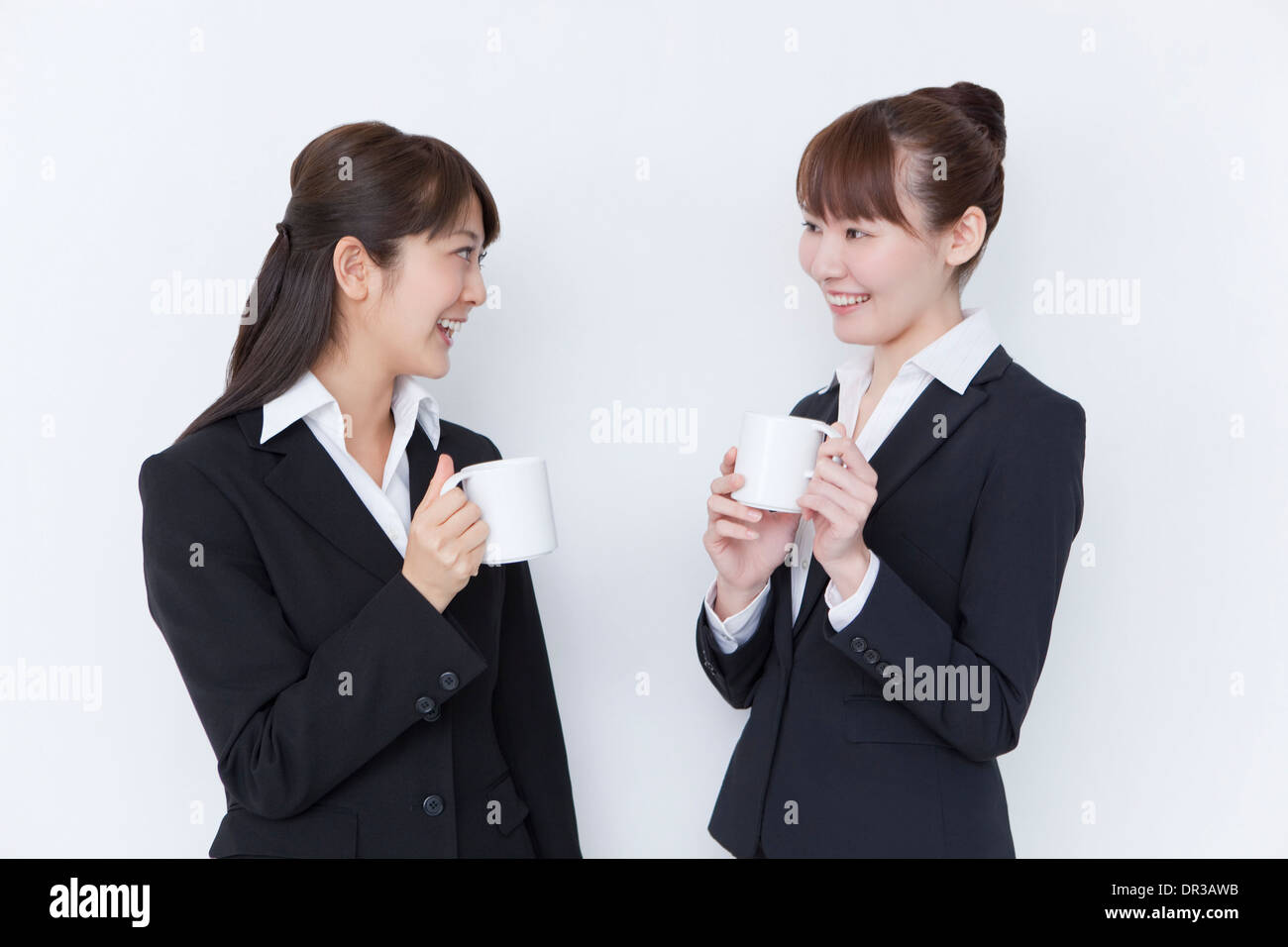 Two young business women having coffee break Stock Photo - Alamy