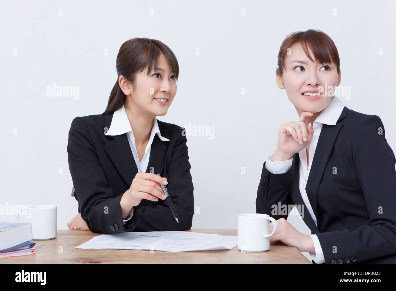 Two young business women having meeting Stock Photo - Alamy