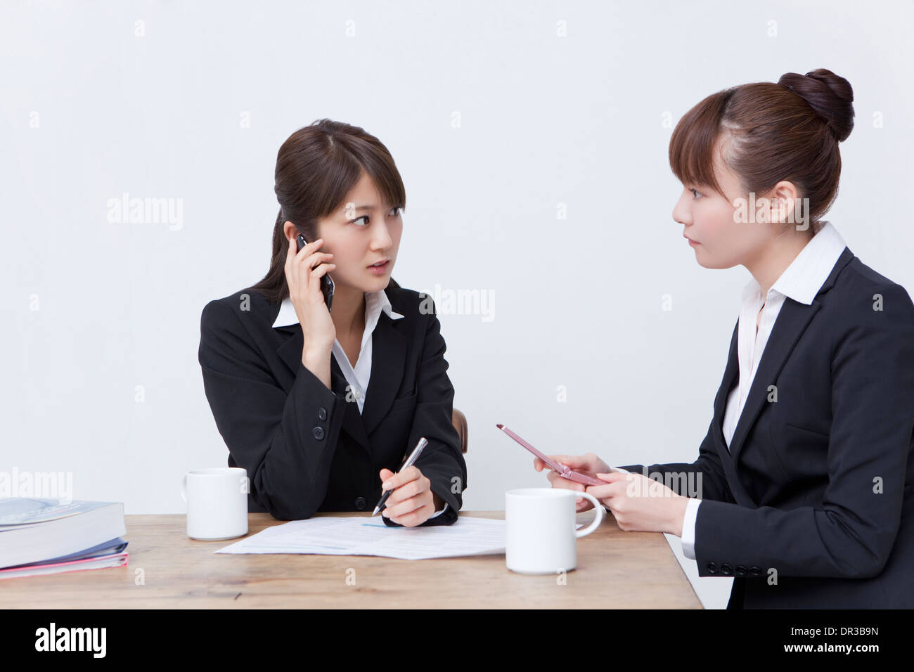 Two young business women having meeting Stock Photo - Alamy