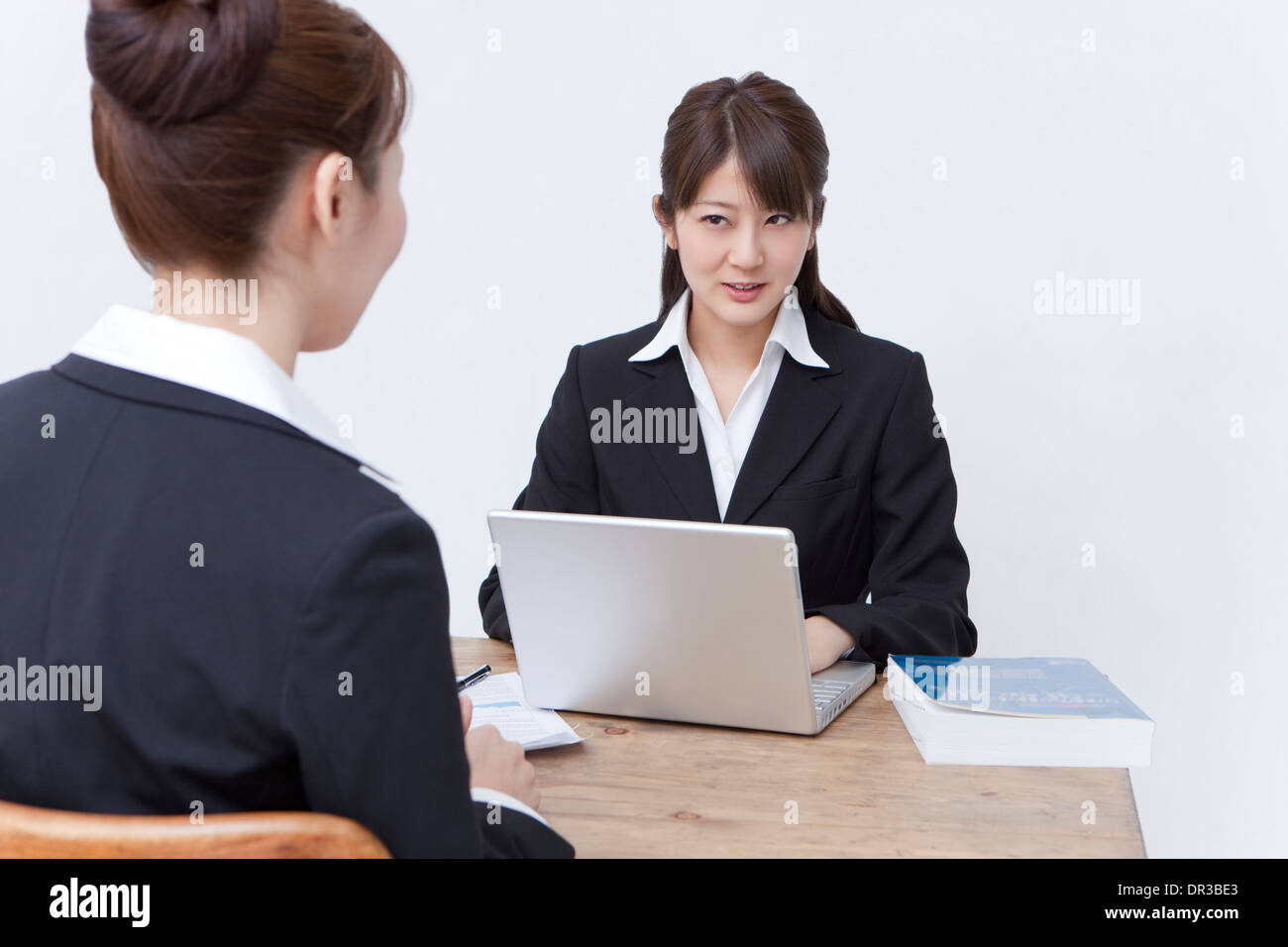 Two young business women having meeting Stock Photo - Alamy