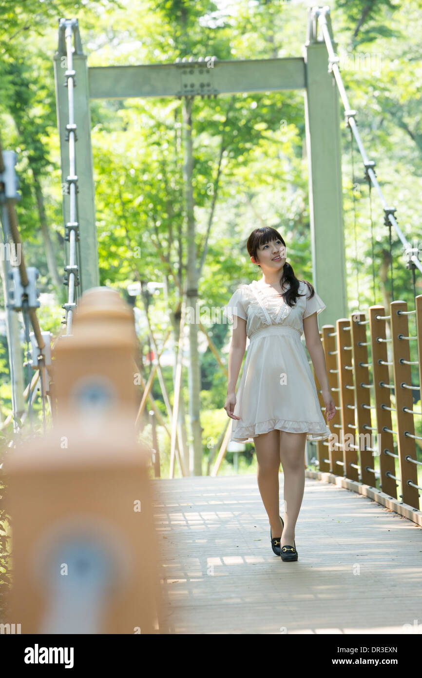 Young woman crossing bridge Stock Photo - Alamy