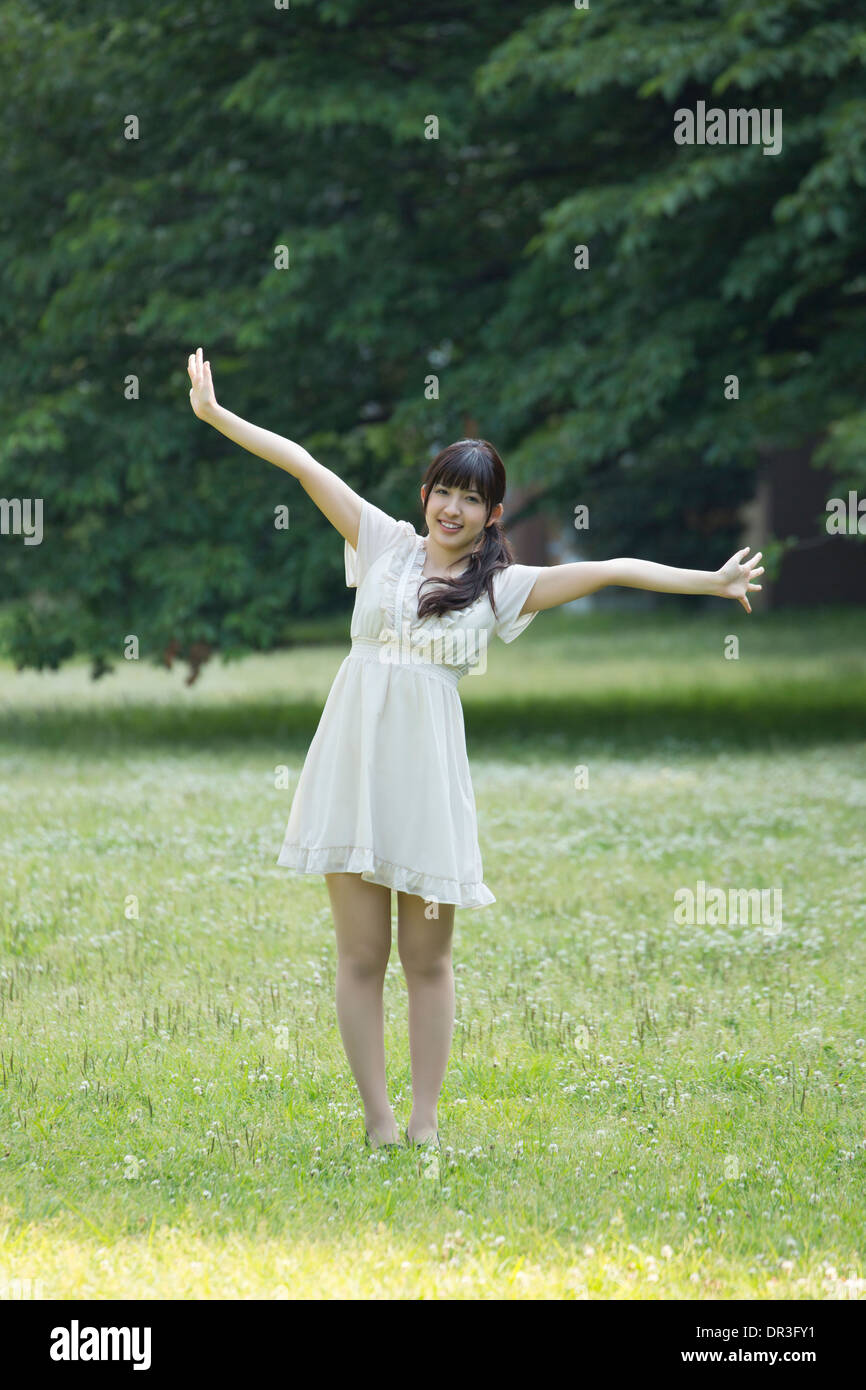 Young woman standing on lawn Stock Photo - Alamy