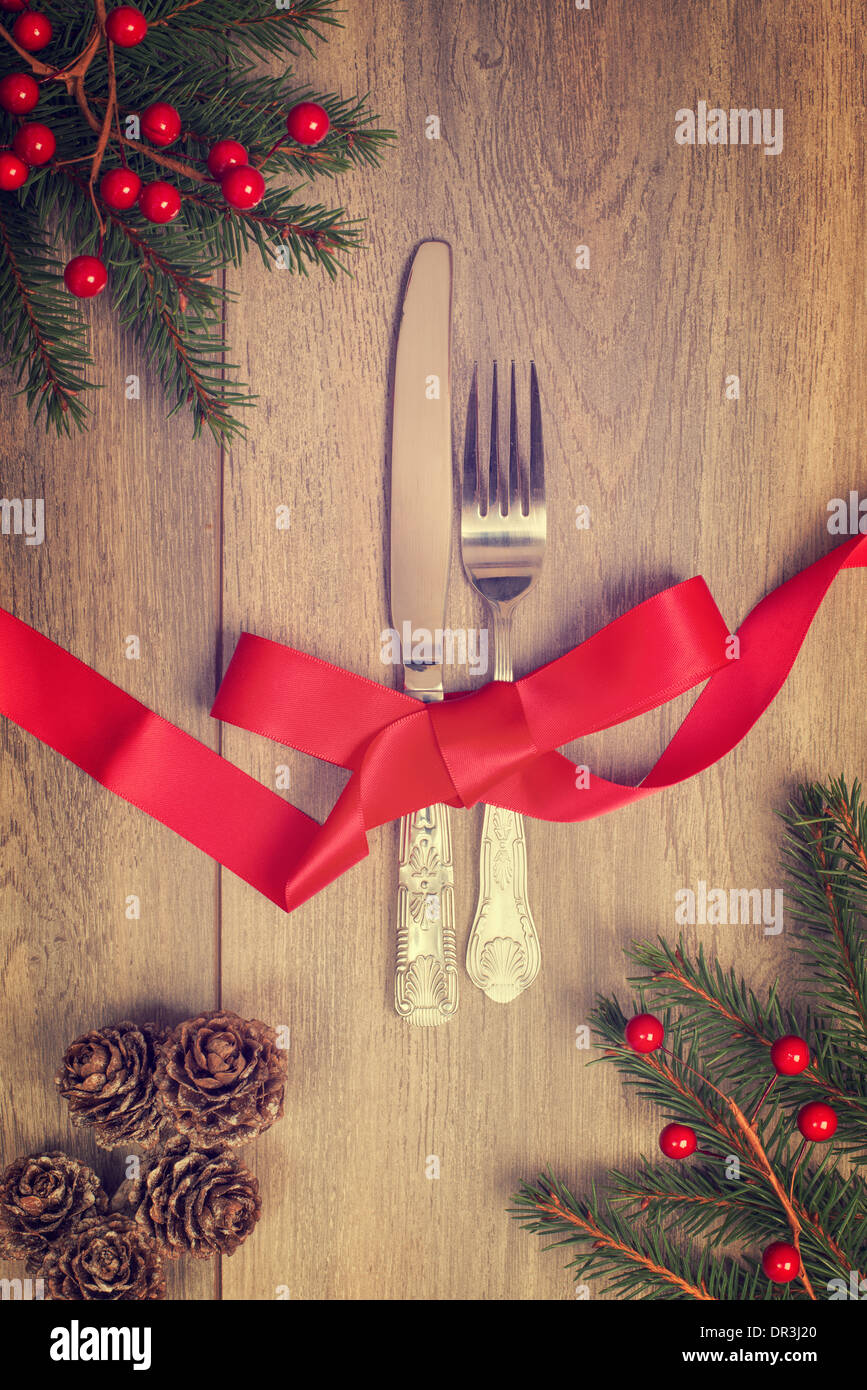 Vintage tone Christmas table setting with knife and fork tied with ...